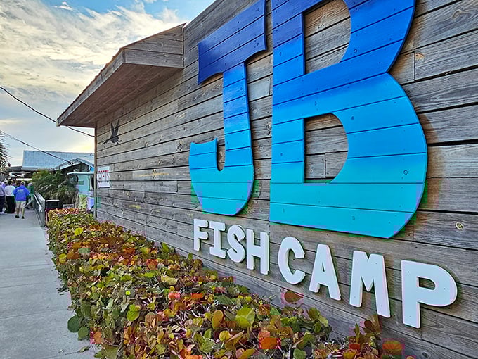The weathered wooden exterior with its gradient blue "JB" sign isn't trying to impress anyone—which is exactly how you know the food inside will be spectacular.