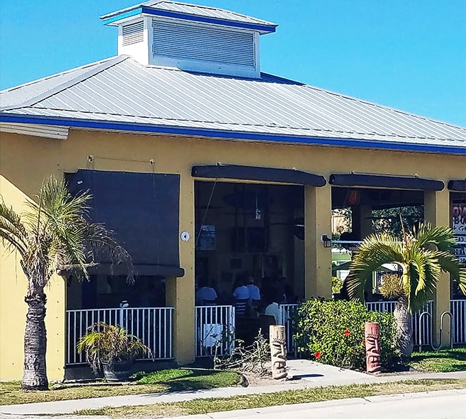 The unassuming yellow exterior of Slow & Low might not scream "food paradise," but that smoky aroma wafting through the palm trees tells the real story.