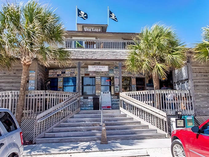 Pirate flags flying high above weathered wood planks—this isn't just a restaurant entrance, it's the gateway to seafood paradise.