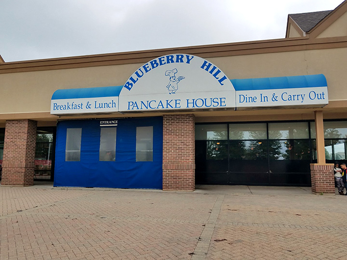 The blue awning of Blueberry Hill Pancake House stands out like a beacon for breakfast enthusiasts. This unassuming exterior houses morning magic within.