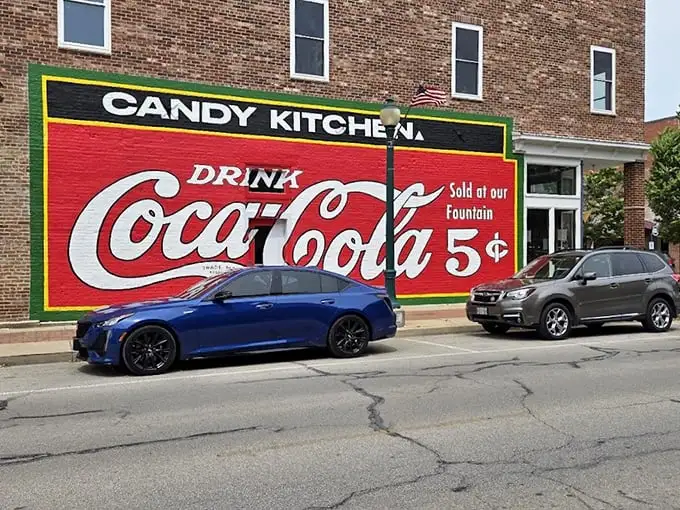 The historic brick façade of Flesor's Candy Kitchen stands as a time capsule in downtown Tuscola, complete with vintage Coca-Cola signage promising sweet nostalgia inside.