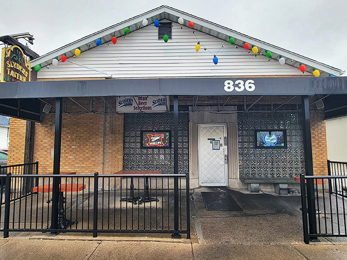 The unassuming exterior of Slyder's Tavern, with its festive string lights, proves once again that the best food often hides behind the most modest facades.