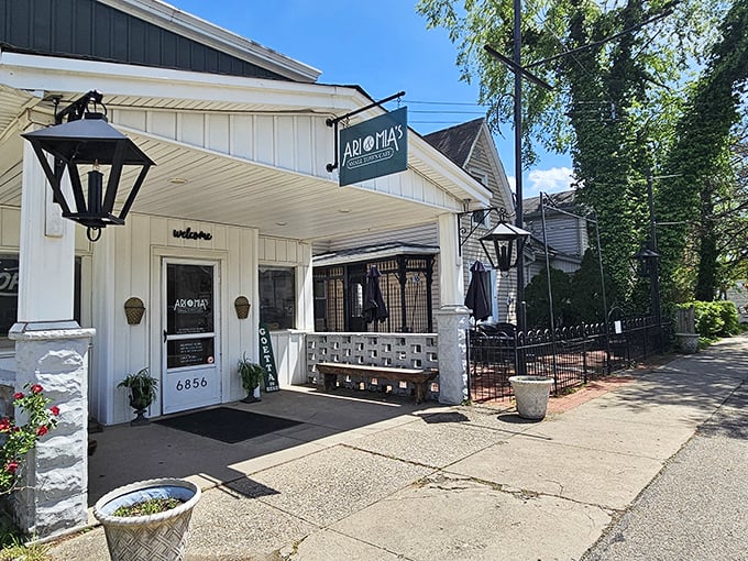 The charming exterior of Ari & Mia's beckons with its vintage lanterns and welcoming "GOETTA" sign—a true Ohio small-town treasure.