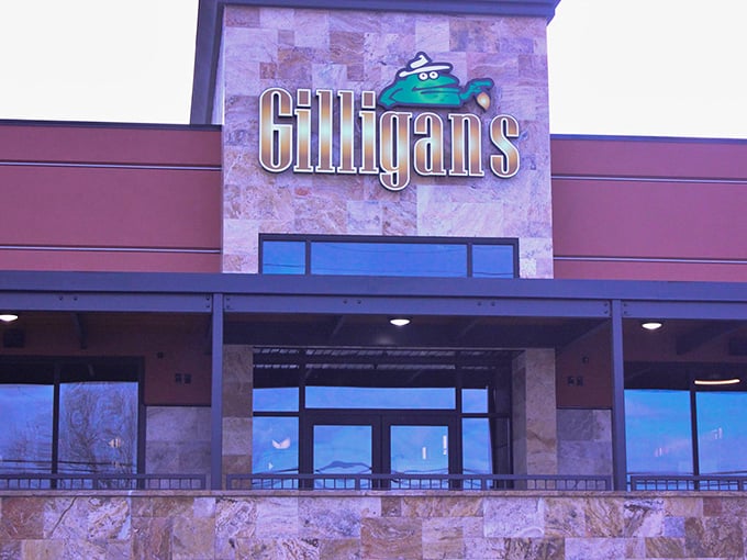 Gilligan's welcoming exterior promises culinary adventures ahead, with stone façade and bright red planters setting the stage for what's inside.