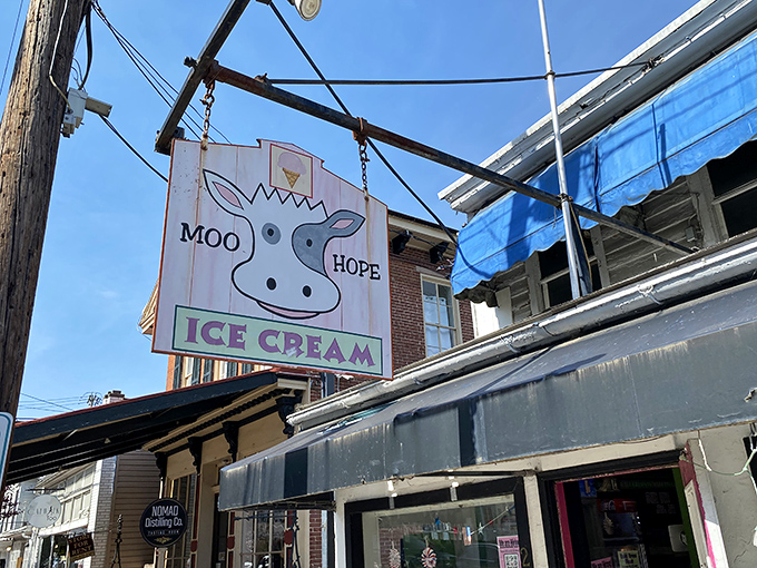 The whimsical cow sign hanging above Moo Hope Ice Cream is like a beacon of dairy delight in New Hope's charming downtown.