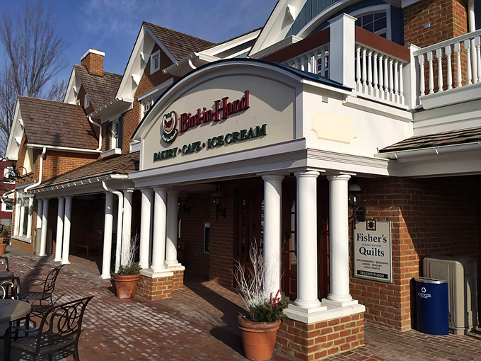 The stately brick exterior of Bird-in-Hand Bakery & Cafe stands like a temple to carbs, promising sweet salvation within those white columns.