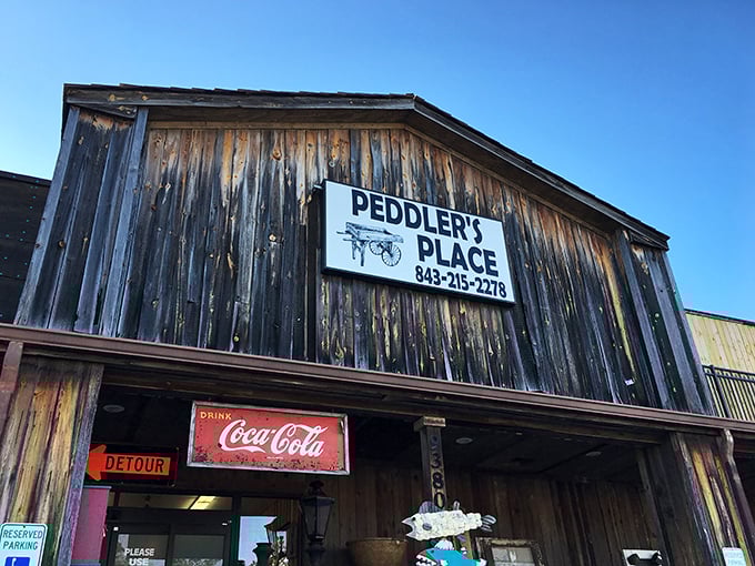 The weathered wooden facade of Peddler's Place isn't just rustic charm—it's a warning sign that your wallet is about to experience a joyful lightening.