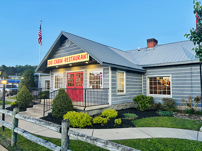 The blue exterior of Log Cabin Restaurant stands like a beacon of comfort food, complete with a welcoming red door that practically screams "get in here and eat something!"