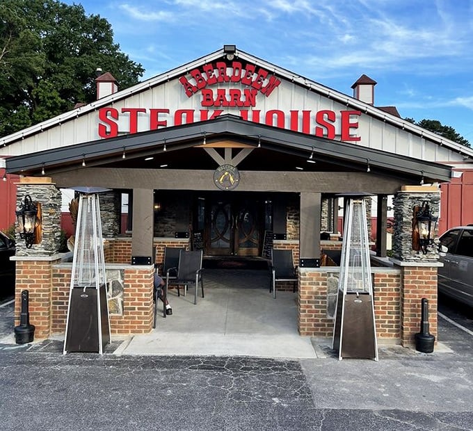 The iconic blue barn with bold red lettering announces your arrival at meat paradise. No trendy minimalism here—just the promise of serious steak.