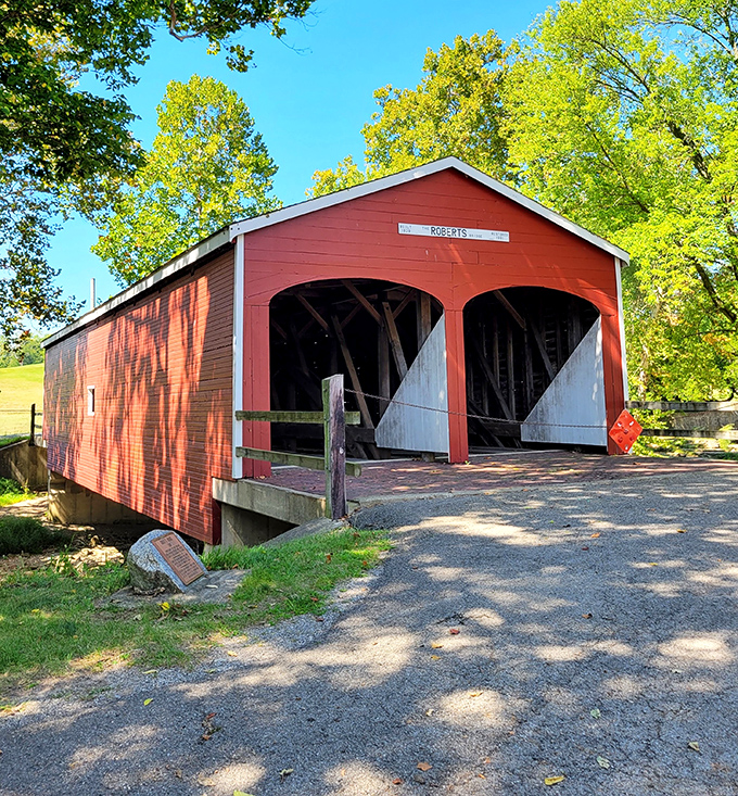 The crimson sentinel of Seven Mile Creek stands proudly against the Ohio sky, its vibrant red siding a beacon to history buffs and romantics alike.