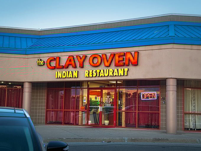 The bright blue roof and bold signage of Clay Oven stand out like a beacon of culinary promise in an unassuming strip mall.