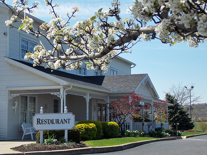 This charming white farmhouse exterior whispers promises of comfort food that'll make your grandmother jealous.