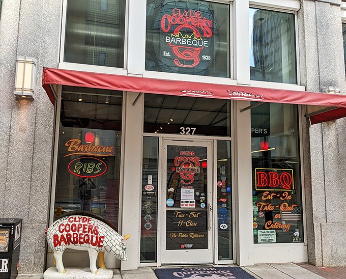 The iconic red awning and pig statue welcome you to Clyde Cooper's – where barbecue dreams come true since 1938.