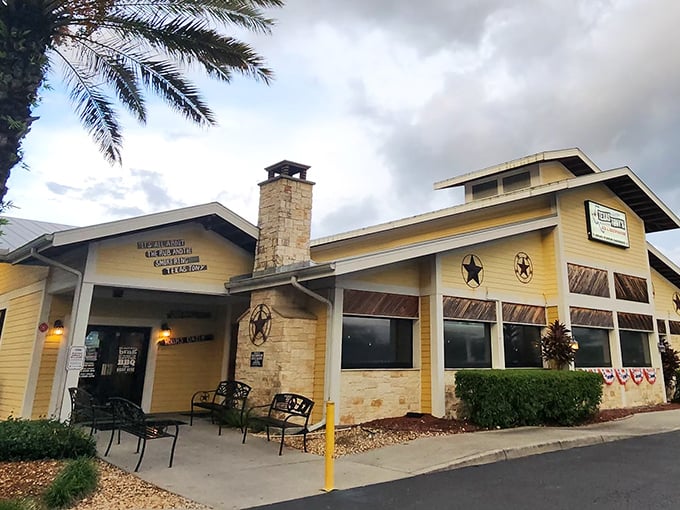 The sunshine-yellow exterior of Texas Tony's stands as a barbecue beacon in Naples, complete with rustic stone chimney and Western star accents.
