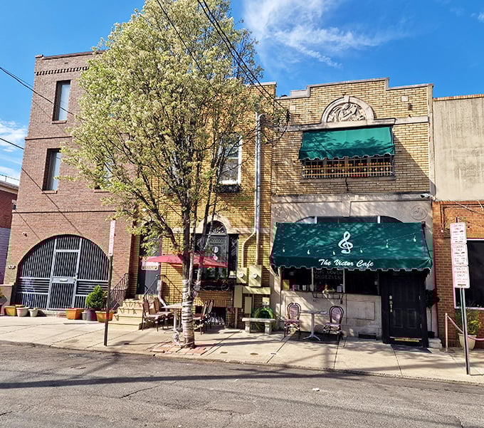 The iconic yellow brick façade of Victor Café stands proudly in South Philly, its green awnings like musical notes against the urban symphony.