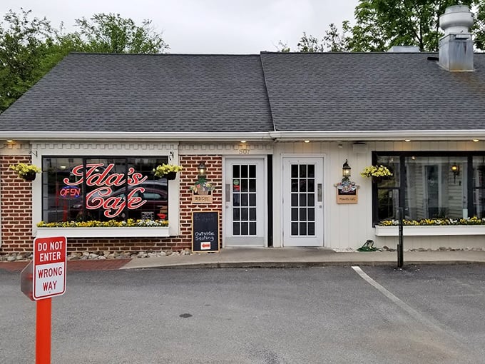 The orange accent wall of Ida's Café pops against the white brick like a breakfast beacon in Lancaster. Their neon sign promises delicious things await inside.