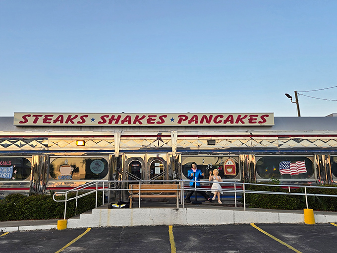 The gleaming silver exterior of All American Diner shines like a time capsule under the Florida sun, promising "STEAKS • SHAKES • PANCAKES" in bold red letters.