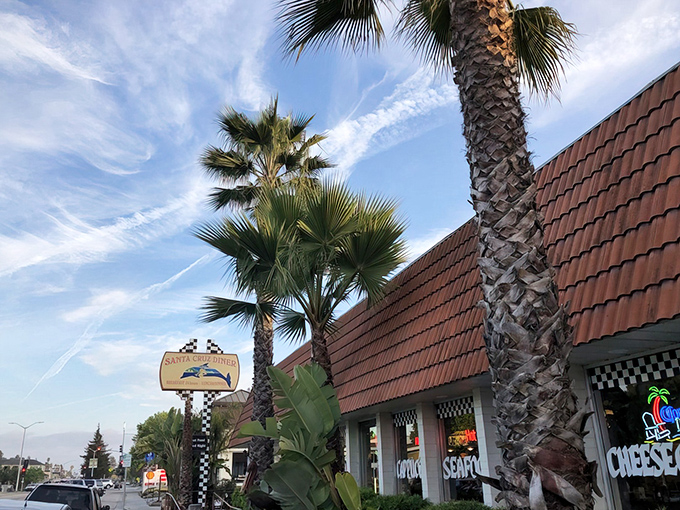 Palm trees frame the iconic red-tiled roof of Santa Cruz Diner, where the checkered sign promises pancakes and California dreams in equal measure.