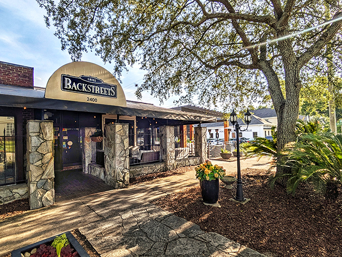 The stone facade entrance to Backstreets Grill stands like a culinary fortress, promising comfort and flavor beneath that iconic arched sign.