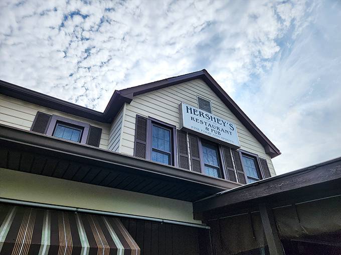 The classic yellow and brown exterior of Hershey's Restaurant stands like a beacon for fried chicken pilgrims, complete with lush hostas and welcoming striped awnings.