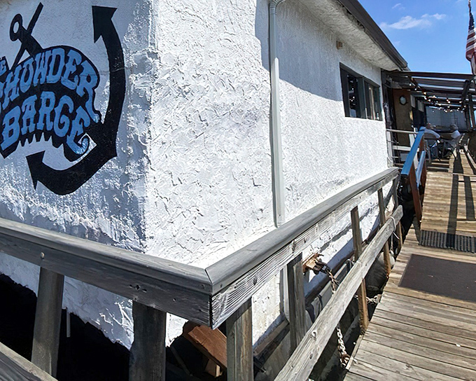 The floating charm of Chowder Barge welcomes seafood lovers with weathered wooden planks and American flag—nautical dining that actually bobs with the tide.