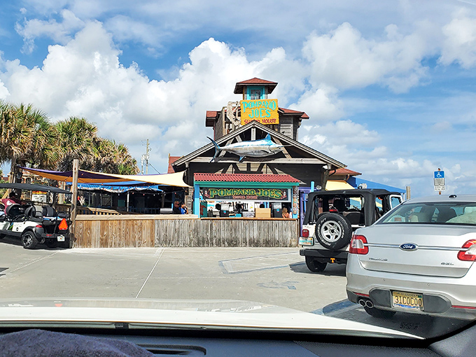 Pompano Joe's weathered wooden exterior isn't trying to impress anyone—yet somehow manages to charm everyone with its colorful Caribbean-inspired architecture perched right on the dunes. 