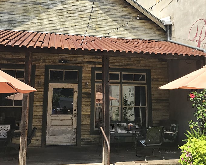 The rustic charm of Fette Sau's exterior beckons like a siren song for barbecue lovers. Weathered wood, brick pavers, and that chalkboard sign promising smoky treasures within.