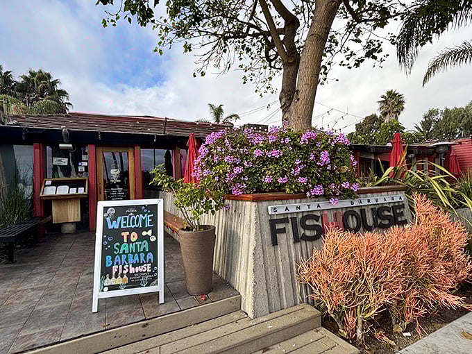 A coastal welcome that feels like a warm hug – vibrant bougainvillea frames the entrance to Santa Barbara FisHouse, where seafood dreams come true.