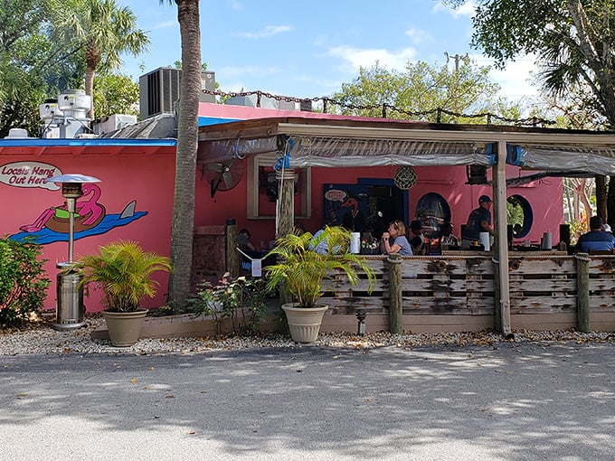 That pink exterior isn't just a building—it's a promise of Florida fun wrapped in Caribbean color. The blue-trimmed windows peek out like portholes on this seafood sanctuary.