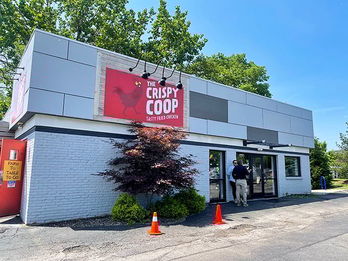 The modern exterior of The Crispy Coop stands out with its bold red signage, promising "Tasty Fried Chicken" that's worth slamming on your brakes for.