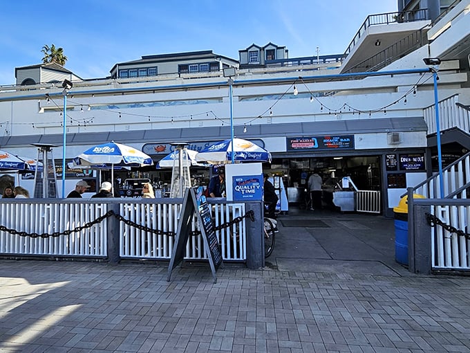 The unassuming entrance to seafood paradise. White picket fences and blue umbrellas welcome you to Quality Seafood, where ocean-to-table isn't a trend—it's tradition.