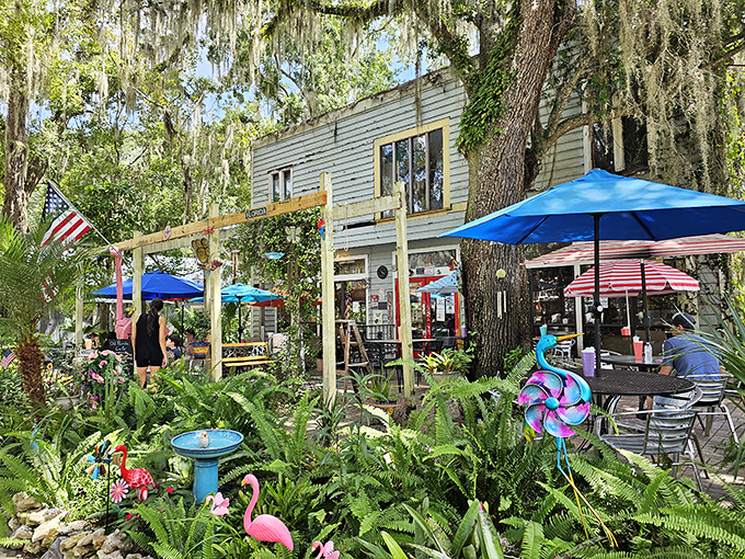 The mint-green exterior with its vibrant red door isn't just inviting—it's practically shouting "Get in here and eat something delicious!" through the Spanish moss.