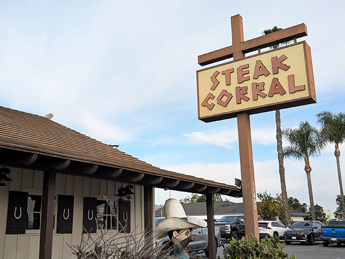 The iconic Steak Corral sign stands tall against the California sky, a beacon of hope for hungry carnivores seeking refuge from trendy food fads.