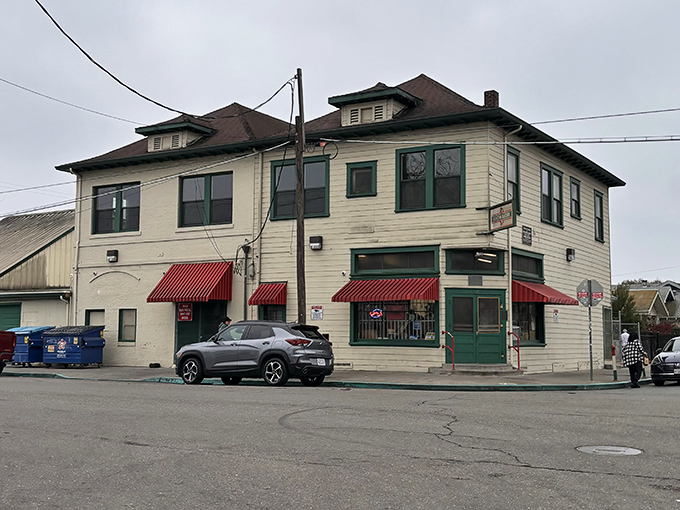 The cream-colored building with distinctive red awnings stands like a time capsule on the corner, beckoning hungry travelers with promises of old-world Italian delights.