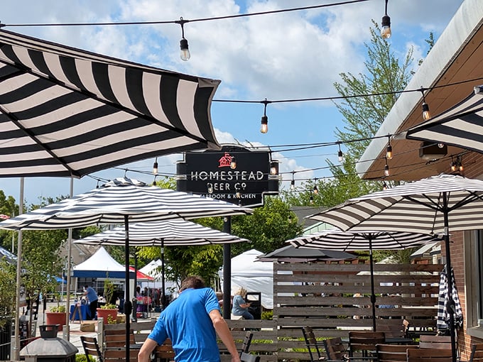 The patio at Homestead beckons with its striped umbrellas and string lights—a perfect spot for summer evenings when Ohio decides to behave weather-wise.