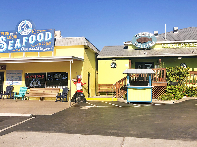 The cheerful yellow exterior of Rusty Bellies promises seafood treasures within, like a maritime version of Willy Wonka's factory—but with stone crabs instead of chocolate.