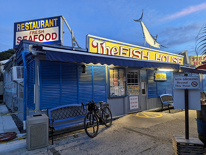 The iconic blue exterior of The Fish House Encore stands proudly in Key Largo, complete with a marlin that seems to say, "Yes, we know our seafood."