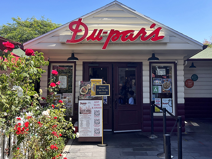 That iconic red neon sign isn't just announcing a restaurant—it's signaling your imminent reunion with pancake perfection at the edge of LA's historic Farmers Market.