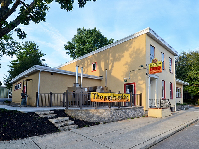 The yellow building with "The pig is smoking" banner isn't just clever marketing—it's a mouthwatering promise that Harvey's delivers on with every bite.