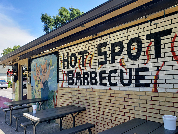 The unassuming yellow brick exterior of Hot Spot Barbecue is like a barbecue speakeasy – no fancy frills, just a white picket fence guarding smoky treasures within.