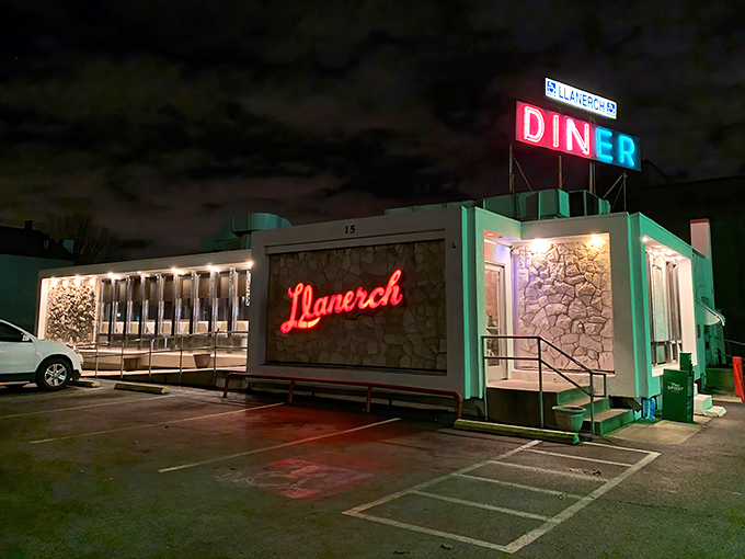 The neon glow of Llanerch Diner's iconic sign beckons hungry travelers like a lighthouse for the famished. Classic mint-green exterior and stone facade scream "authentic American diner experience."