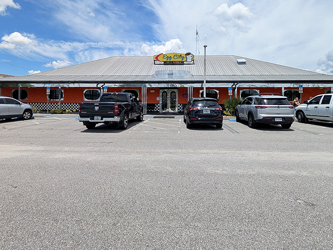 The vibrant orange exterior with classic black-and-white checkerboard trim isn't just eye-catching—it's practically sending breakfast smoke signals to hungry travelers on the highway.