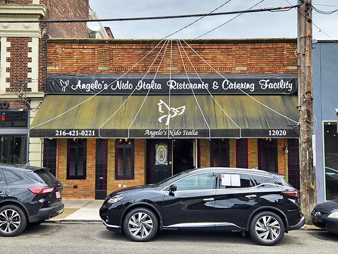 The unassuming brick facade of Angelo's Nido Italia beckons hungry travelers with its classic awning and promise of authentic Italian cuisine within.