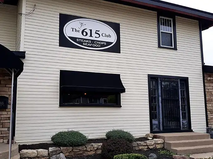 The cream-colored exterior with stone accents and black awnings whispers "classic Wisconsin supper club" without shouting. Culinary treasures await behind that unassuming façade.