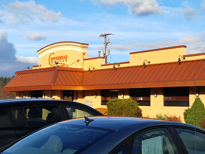 The warm beige exterior of Copperhead Grille welcomes hungry travelers like a culinary lighthouse guiding ships to delicious harbor. That patio practically begs for summer evenings.