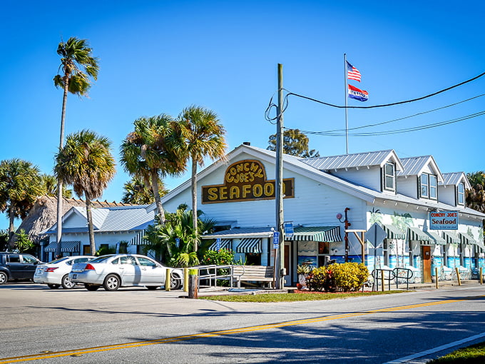 The classic Florida seafood joint equation: palm trees + weathered white building + bold "SEAFOOD" sign = paradise found. No reservations required for the memories.