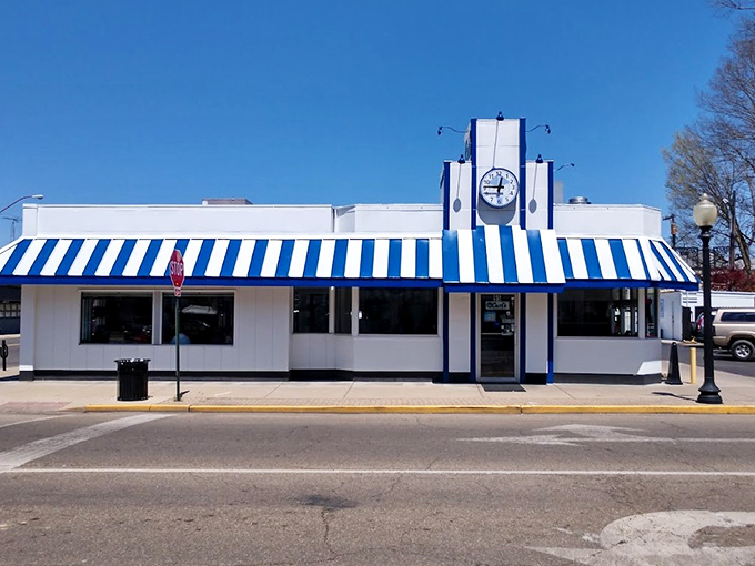 That iconic blue and white awning isn't just eye-catching—it's a time machine disguised as a diner, beckoning hungry travelers with promises of comfort food perfection.