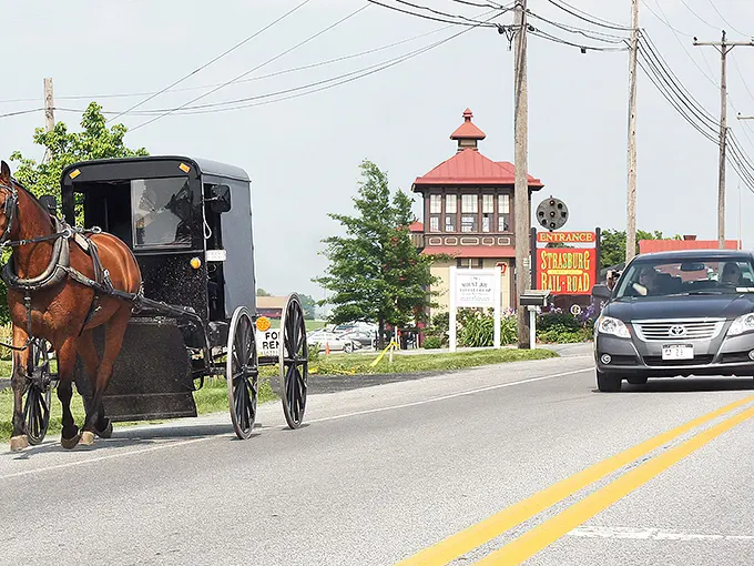Where modern meets traditional – Amish buggies share the road with cars as they have for generations at Strasburg's iconic entrance.