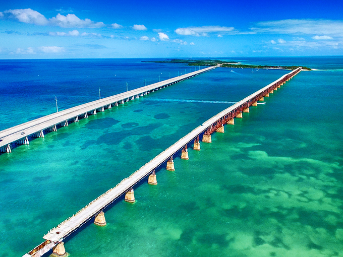 The ultimate road trip fantasy: a ribbon of asphalt suspended between impossible shades of blue, connecting emerald islands like a necklace of tropical pearls.