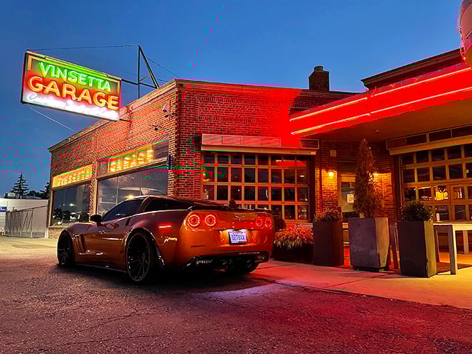 That neon glow against fresh snow isn't just a sign—it's a beacon calling hungry travelers home. Woodward Avenue's automotive shrine transforms into a culinary sanctuary after dark.